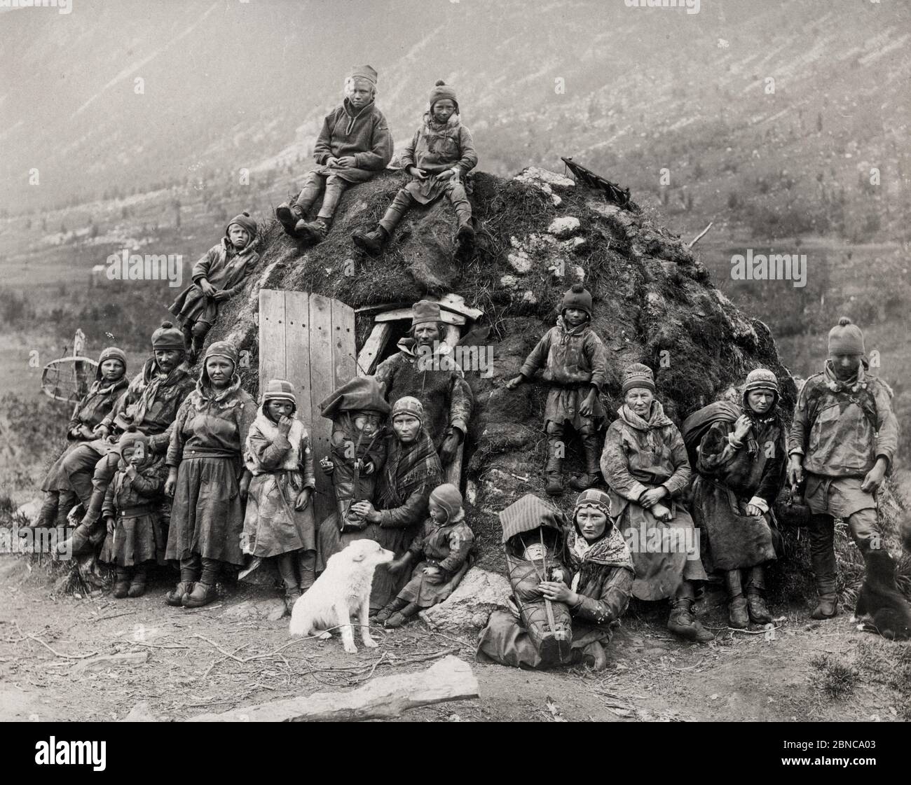Sami indigenous family with their dog outside their home, probably ...