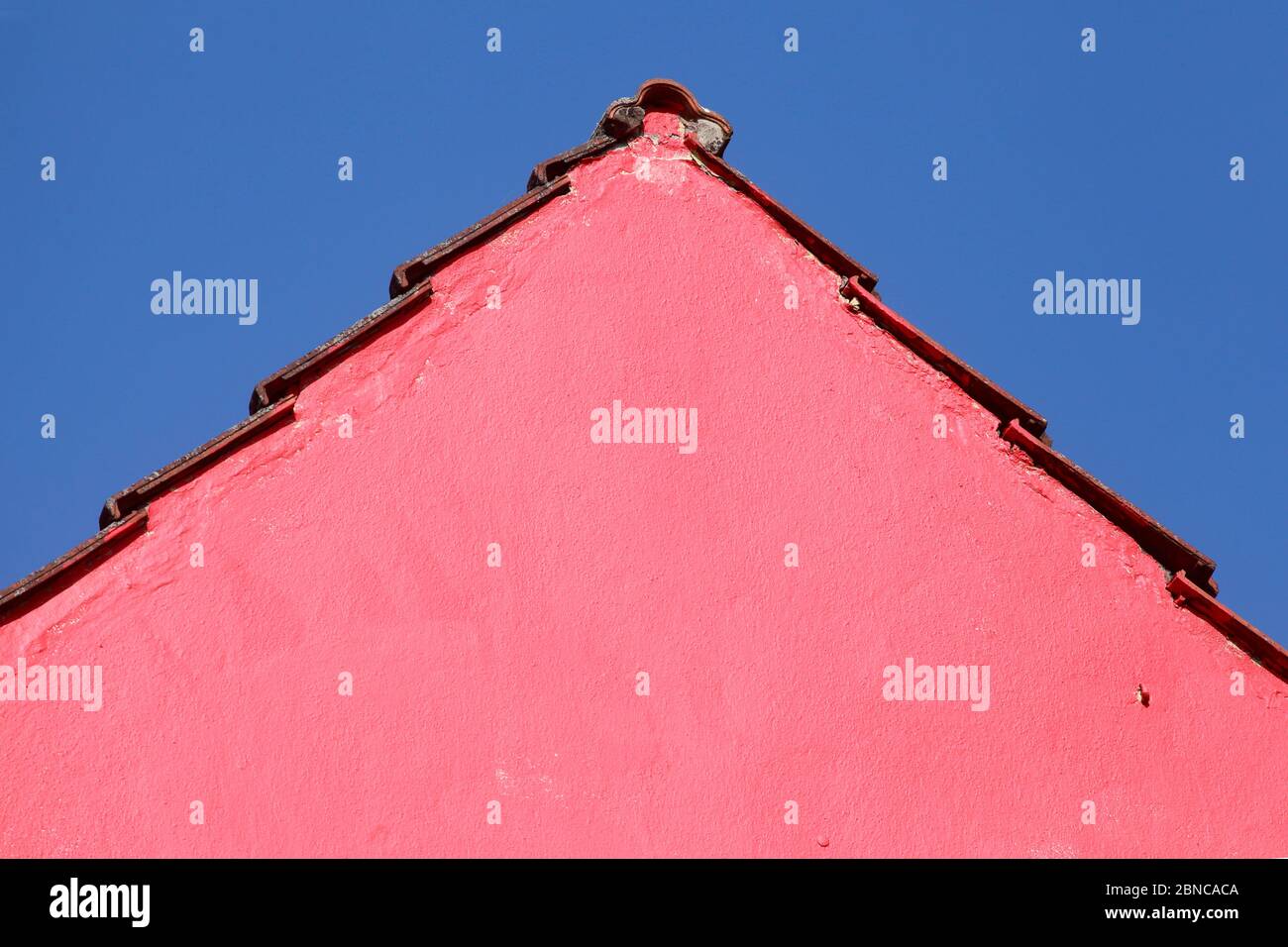 Roof, pink house wall, roof edge, blue sky Stock Photo - Alamy