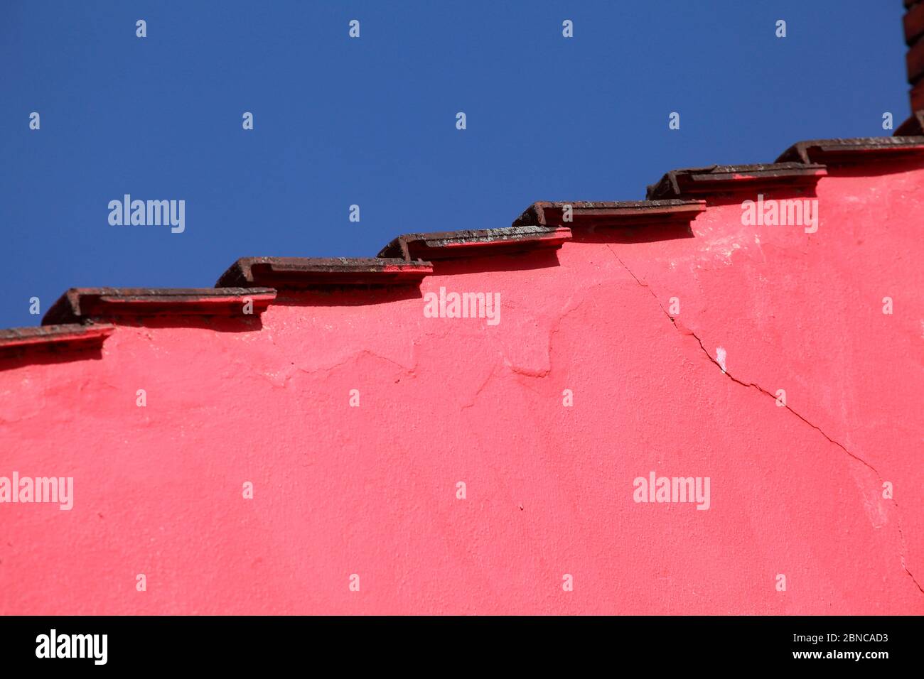 Roof, pink house wall, roof edge, blue sky Stock Photo - Alamy