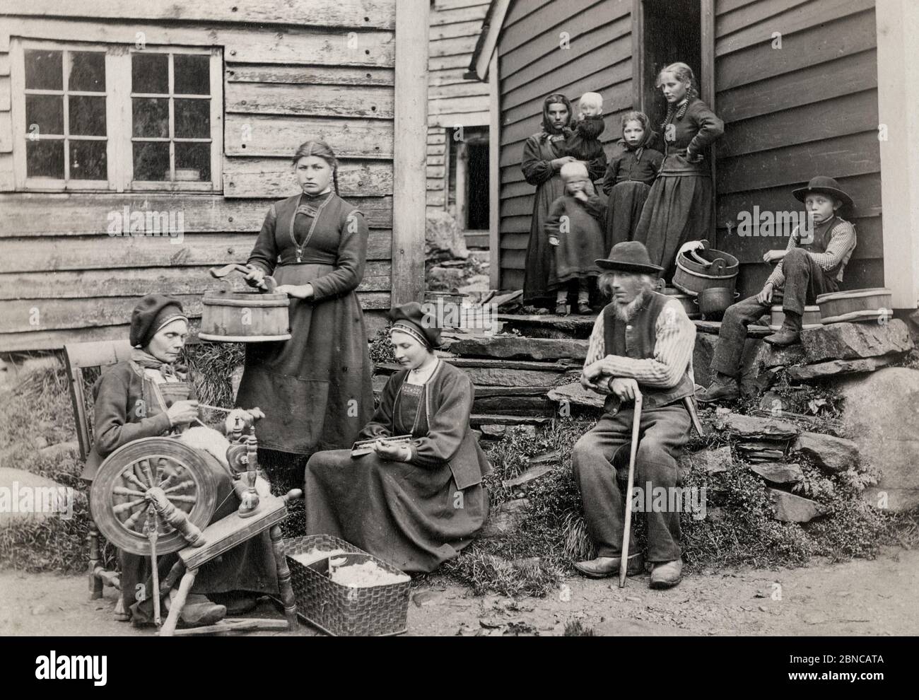 Norway, rural family outside their home with spinning wheel Stock Photo ...
