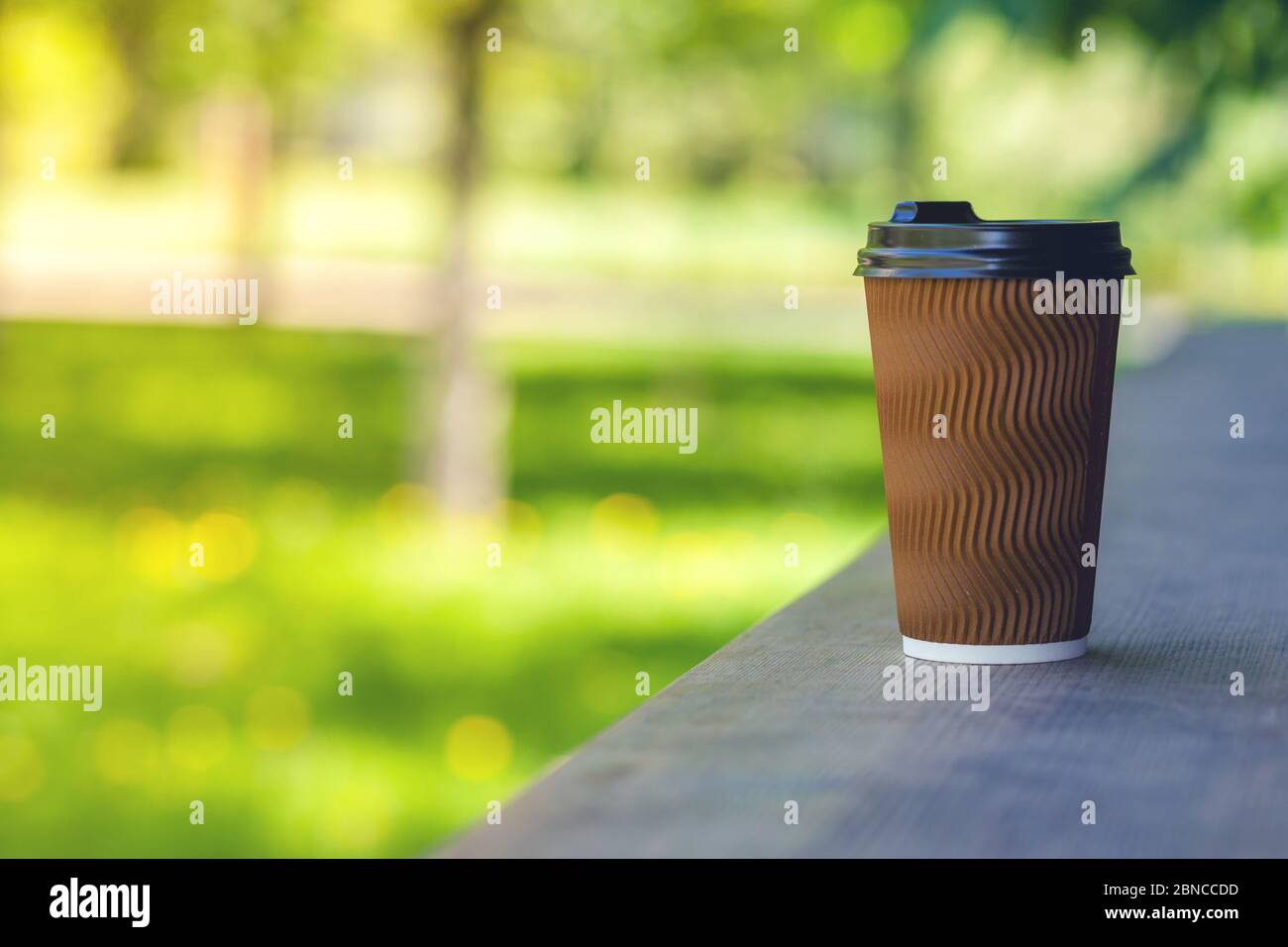 A paper cup of coffee on a wooden bar counter on the street Stock Photo ...