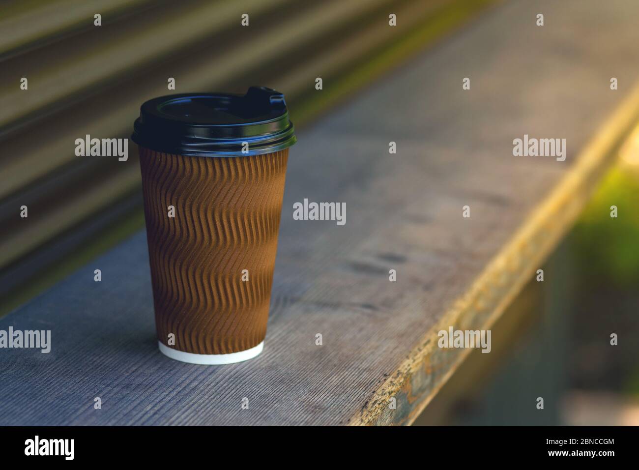 A paper cup of coffee on a wooden bar counter on the street Stock Photo ...