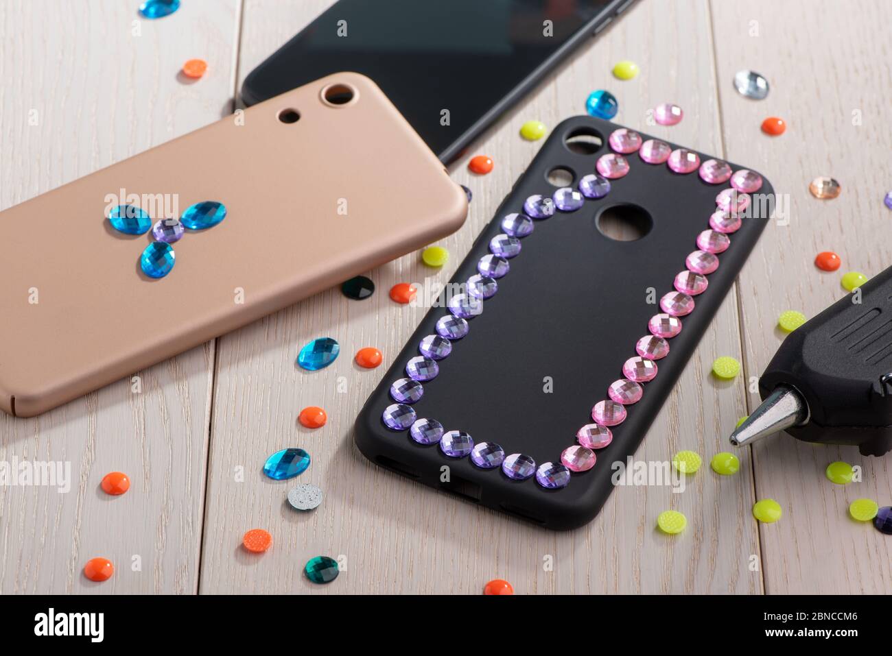 Phone cases being decorated with various rhinestones Stock Photo - Alamy
