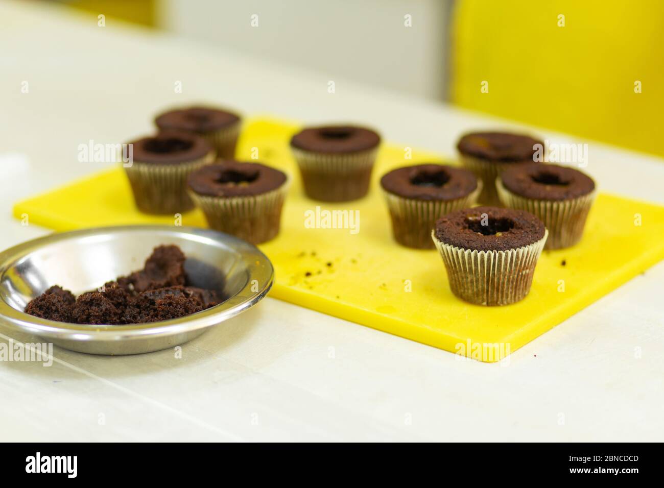 The process of making chocolate cupcakes with sweet cream. Creation of cakes by professional ...