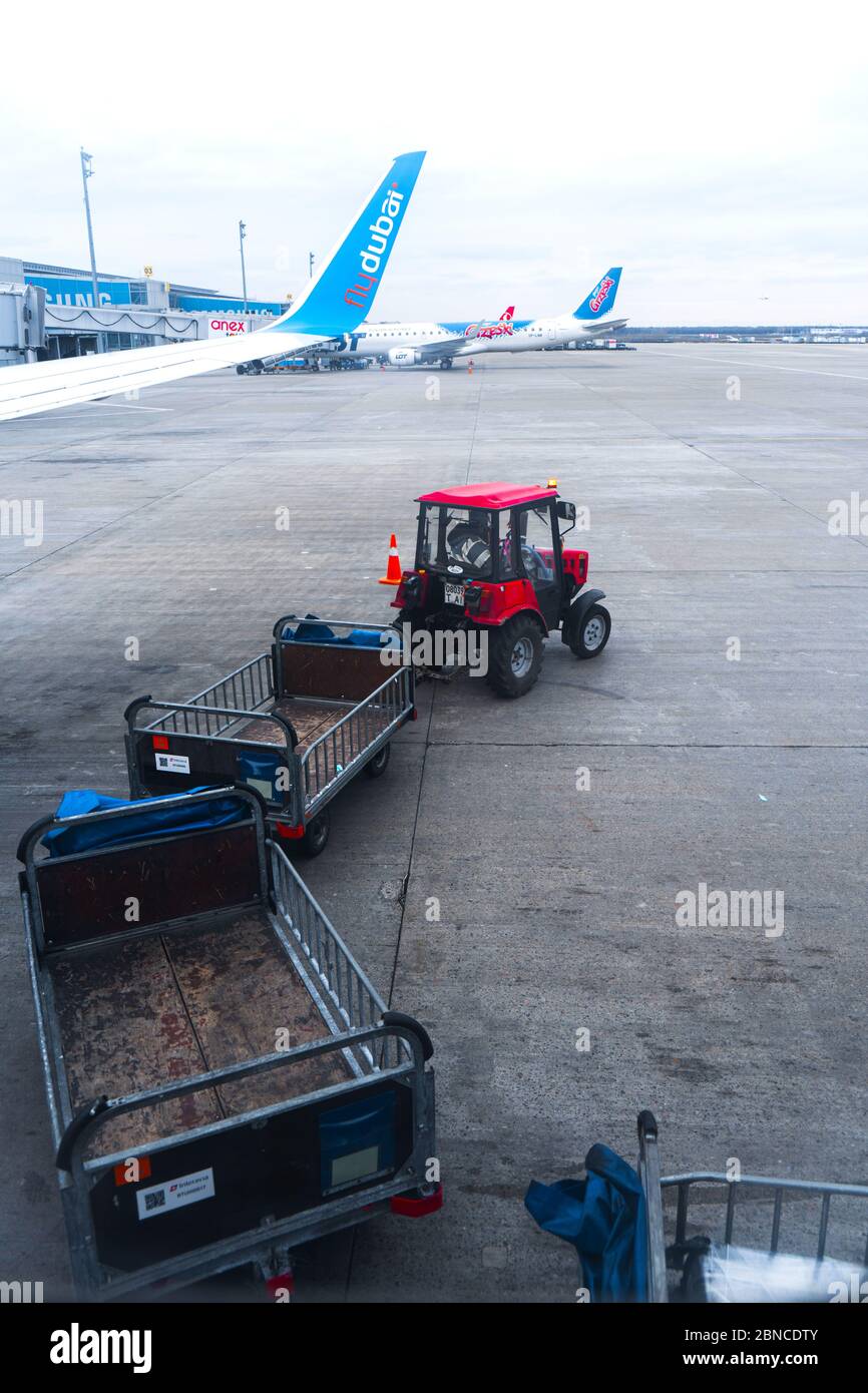 a tractor with a trailer for transporting passenger luggage between an ...