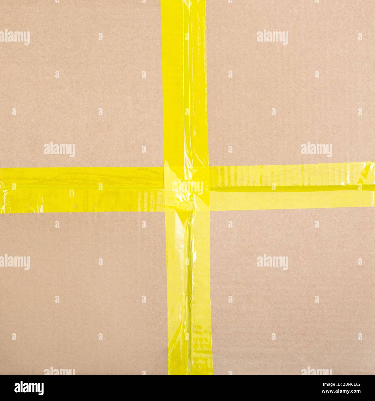 Cardboard background with a yellow sticky tape Stock Photo - Alamy