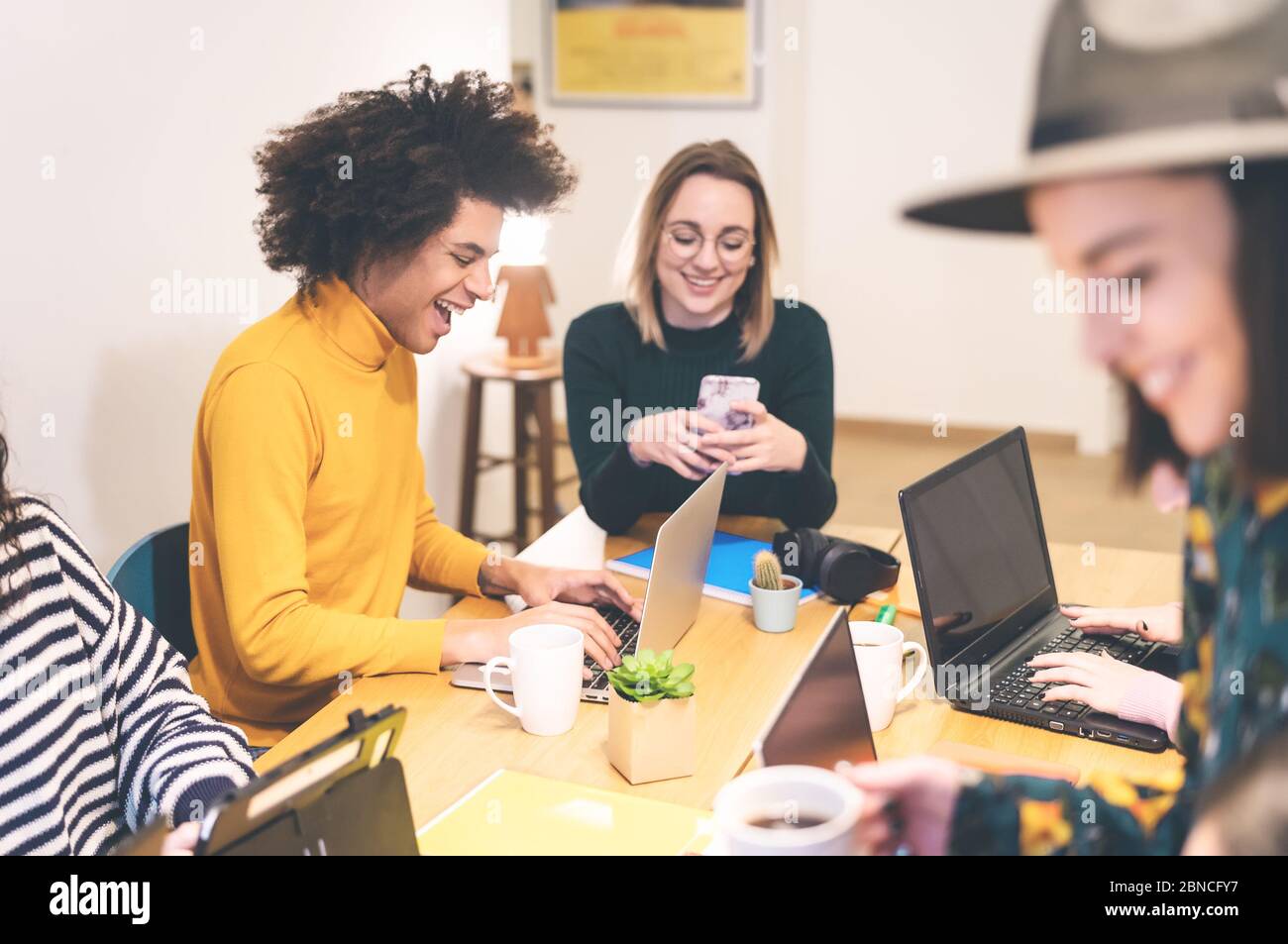 Happy young people working together inside office - Multiracial friends ...