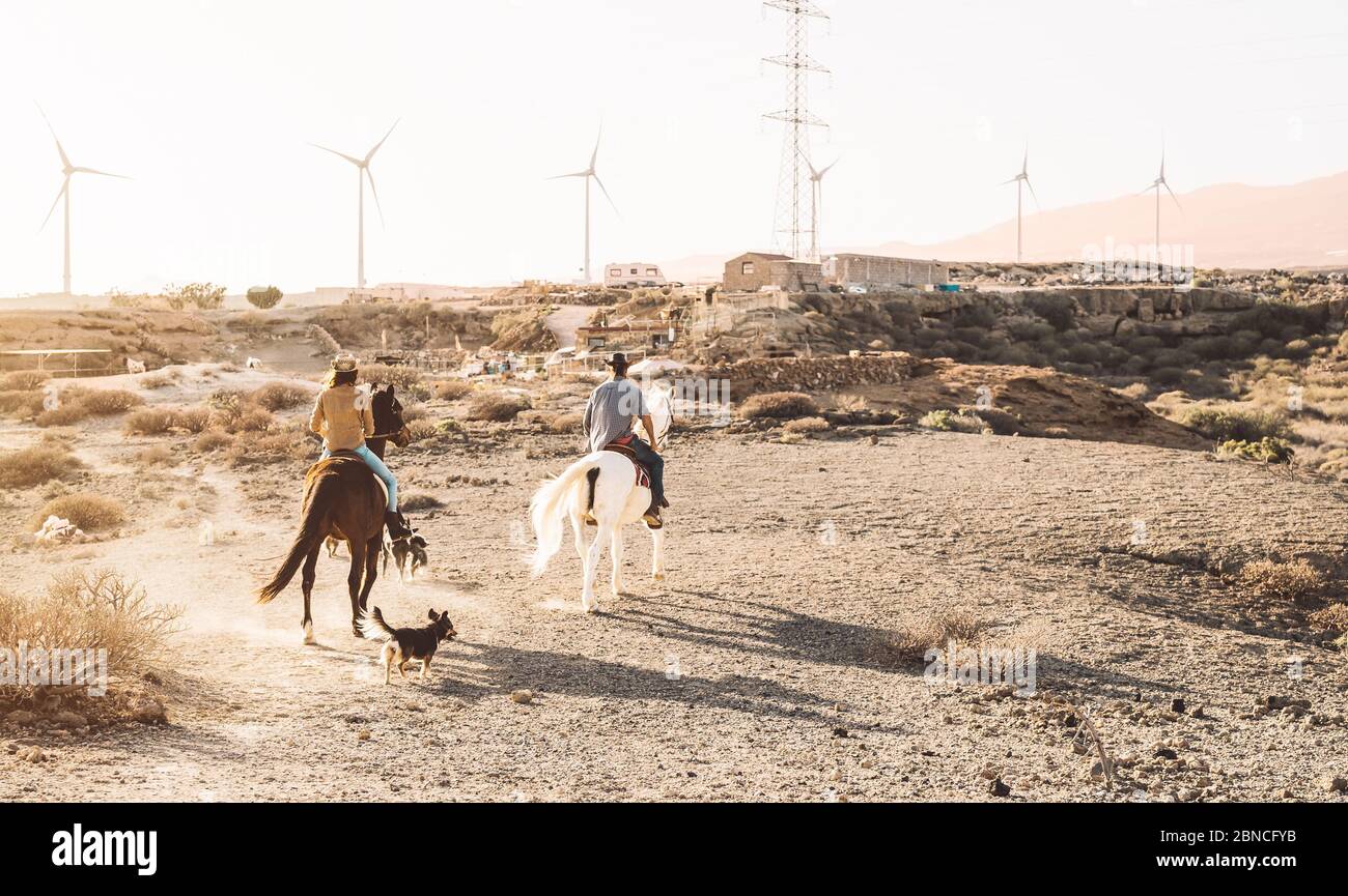 Young people riding horses in desert - Horseback travel people having ...