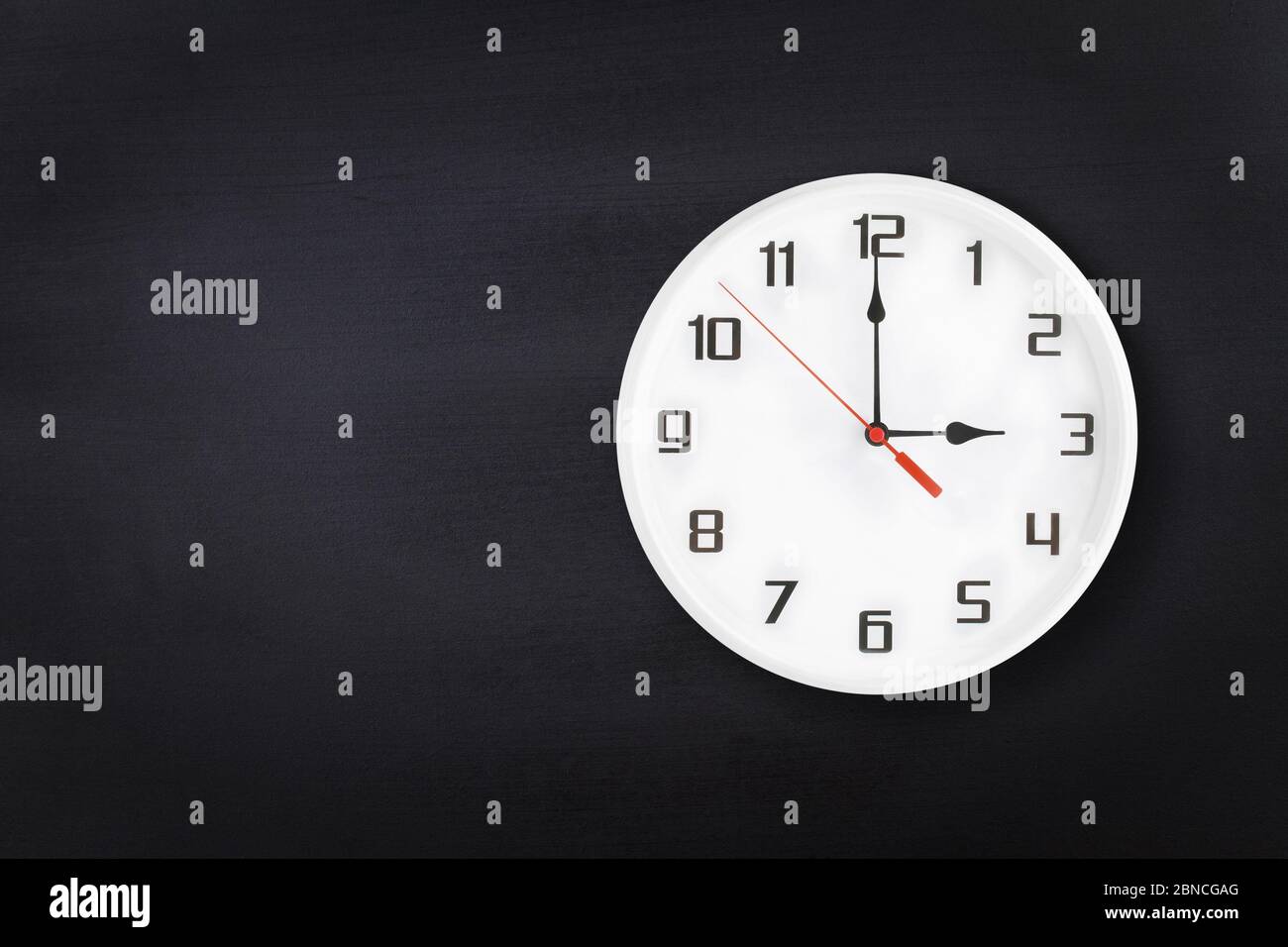 White wall clock on black chalkboard background. 3 a.m. or 3 p.m Stock ...
