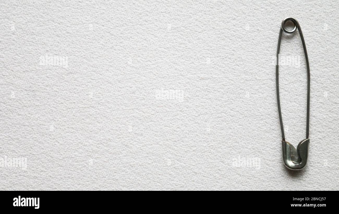 One closed safety pin isolated on white background. Negative space ...