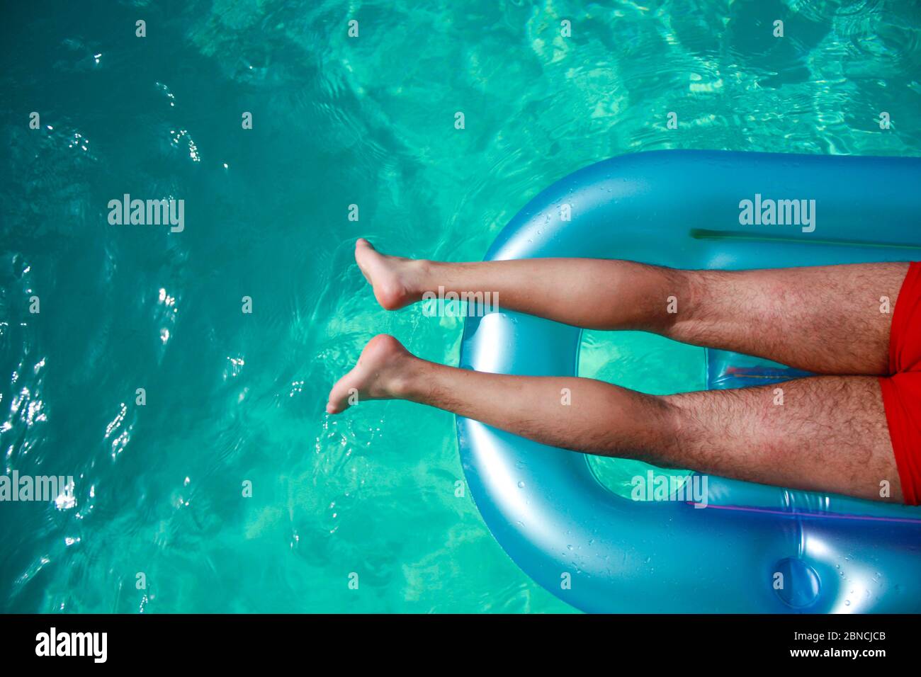 Sunbathing in the pool - Top view of half body of a man on an ...