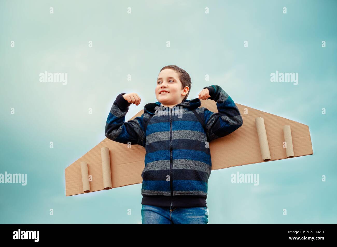 Boy dreams of becoming an aviator. Child playing with wings airplane ...
