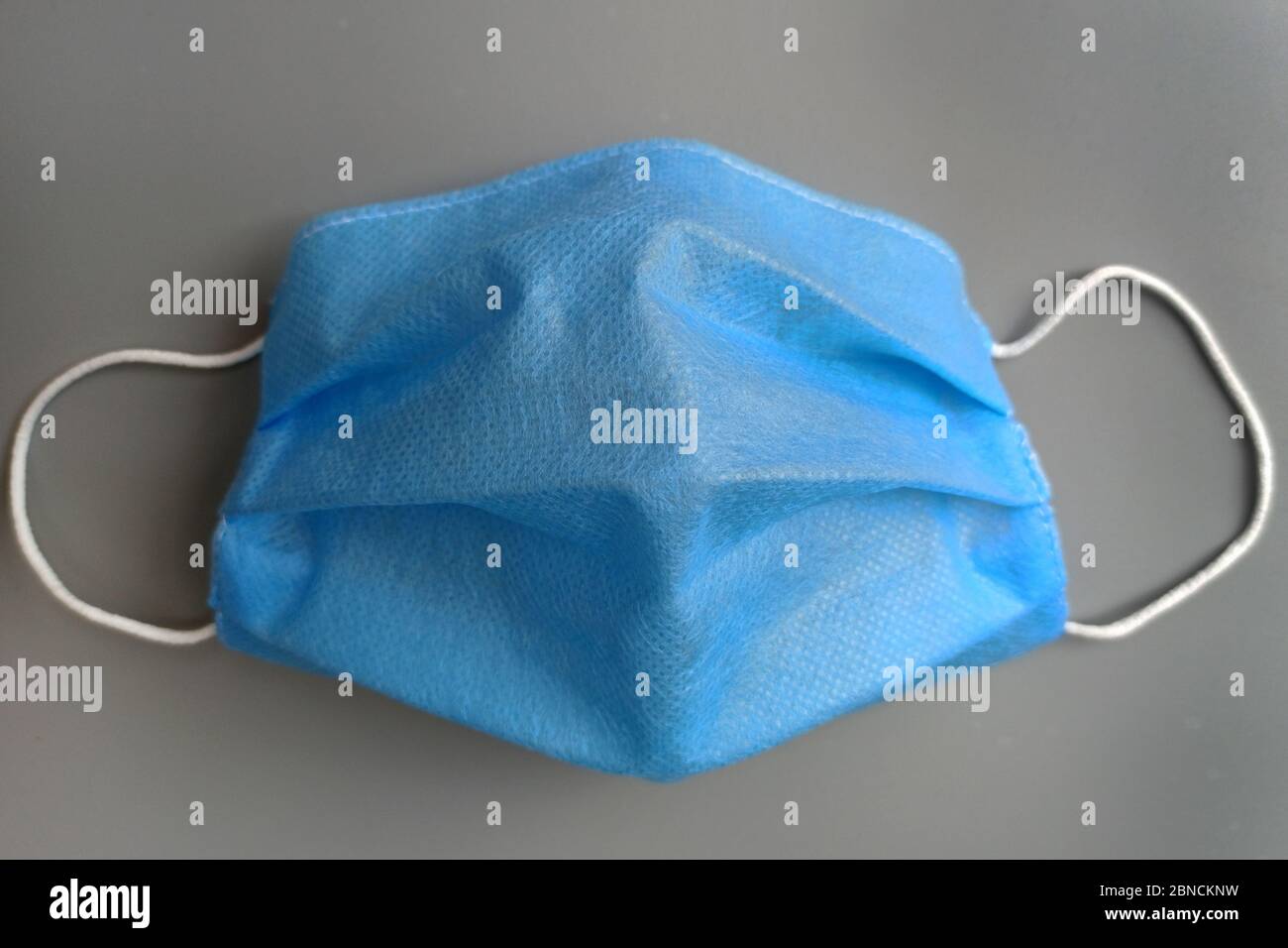 Disposable blue face mask on a gray background. Mask with white elastic ...