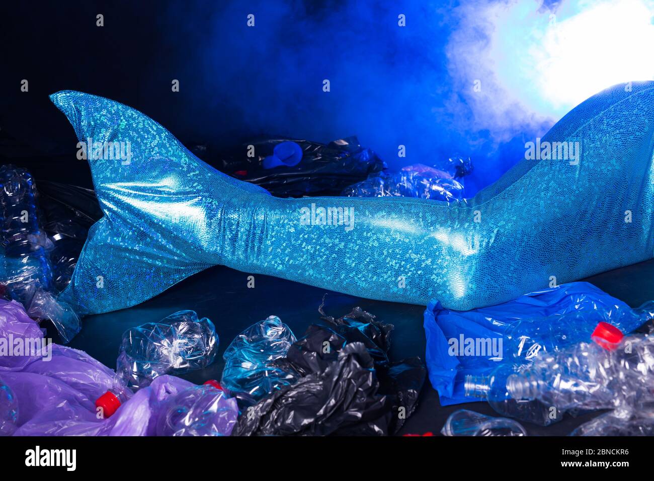 Close-up of fairytale mermaid in polluted ocean. Plastic trash and ...