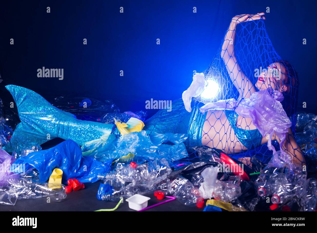 Fantasy mermaid in deep ocean sad because water pollution. Plastic ...
