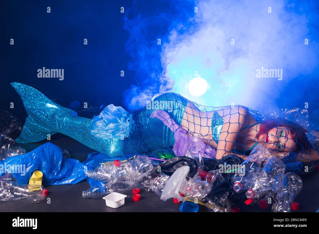 Fantasy mermaid in deep ocean sad because water pollution. Plastic ...