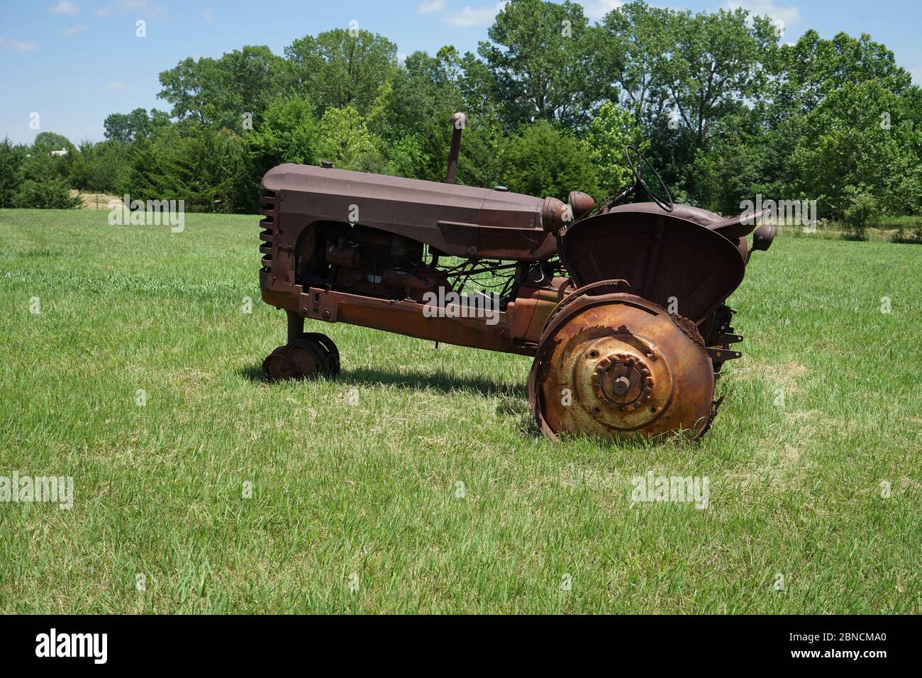 A rusty old farm tractors sits on a prairie in a rural area Stock Photo ...