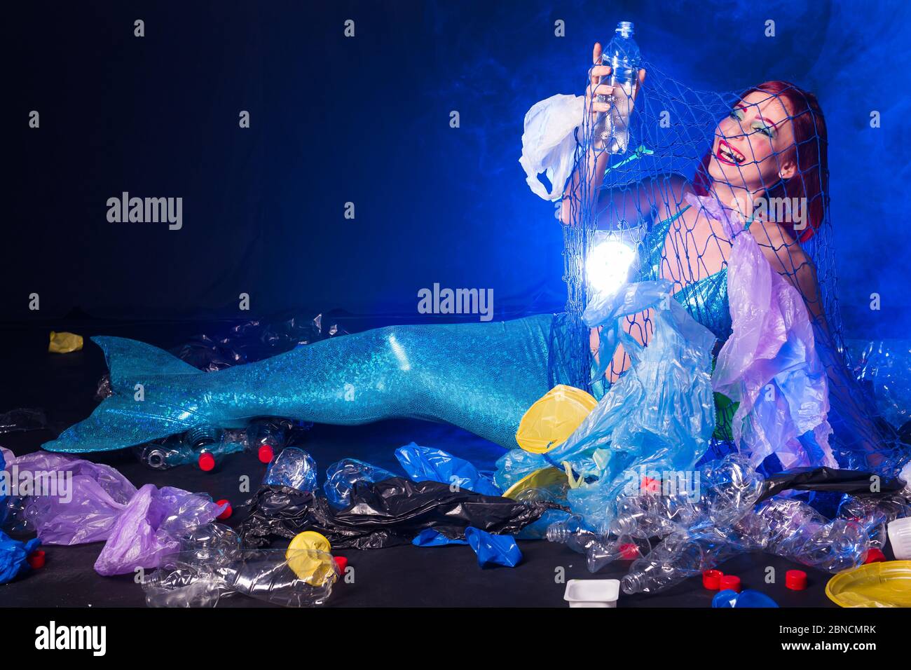 Stupid fairytale mermaid in polluted ocean. Plastic trash and garbage ...