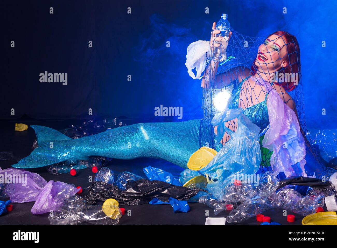 Fantasy stupid mermaid in deep ocean. Plastic trash and bottles ...