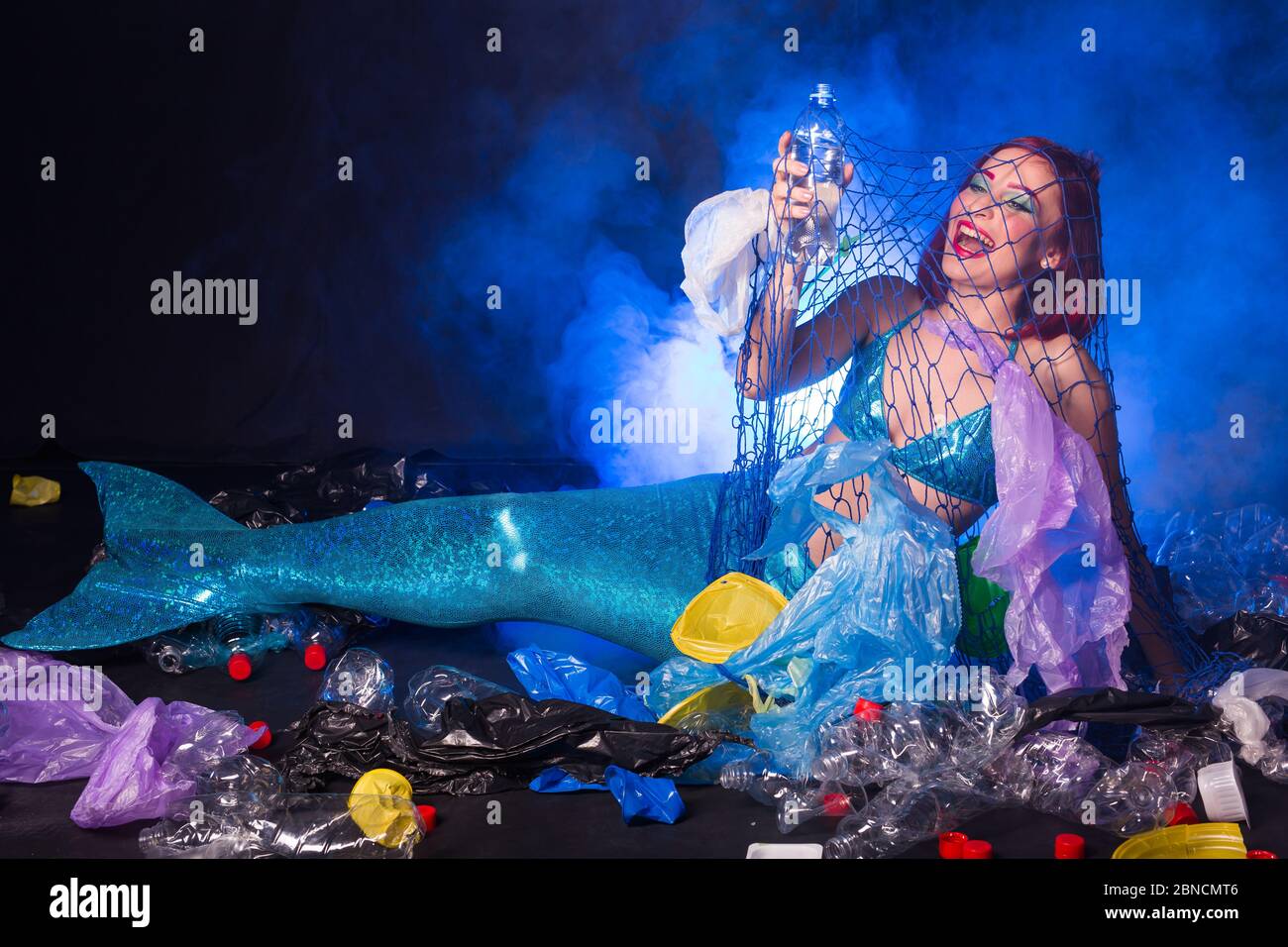 Stupid fairytale mermaid in polluted ocean. Plastic trash and garbage ...