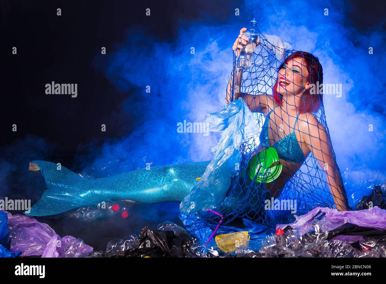 Ocean pollution, rubbish in the water. Stupid fairytale mermaid in ...