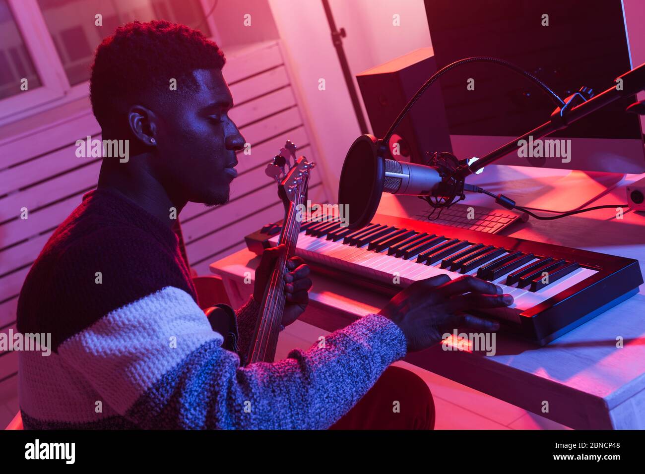 African american professional musician recording synthesizer in digital ...