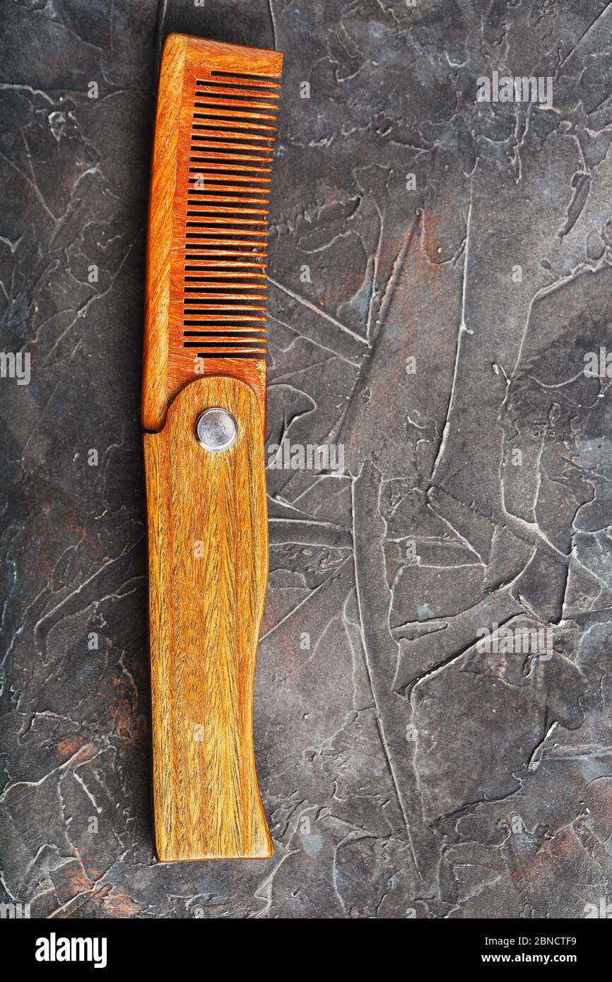 Folding wooden comb on a black background. Close up Stock Photo - Alamy