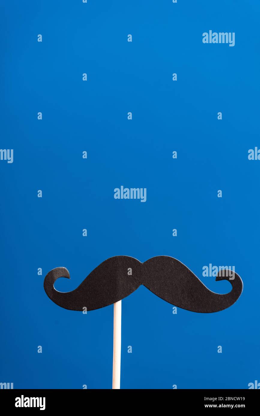 Decorative black paper crafted fake mustache on white stick isolated on ...