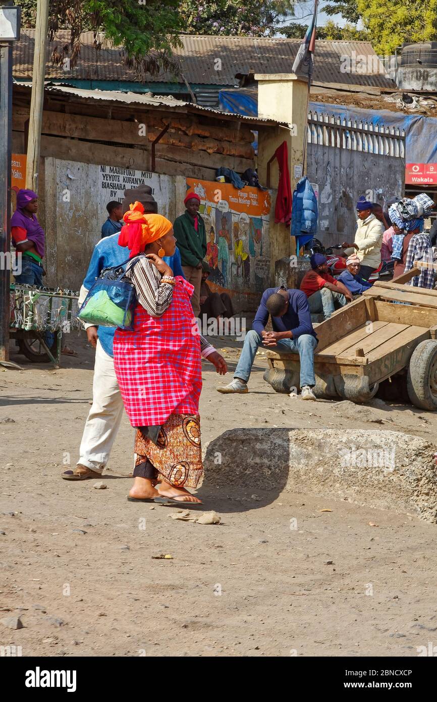 street scene, woman walking, colorful traditional clothing, men hanging ...
