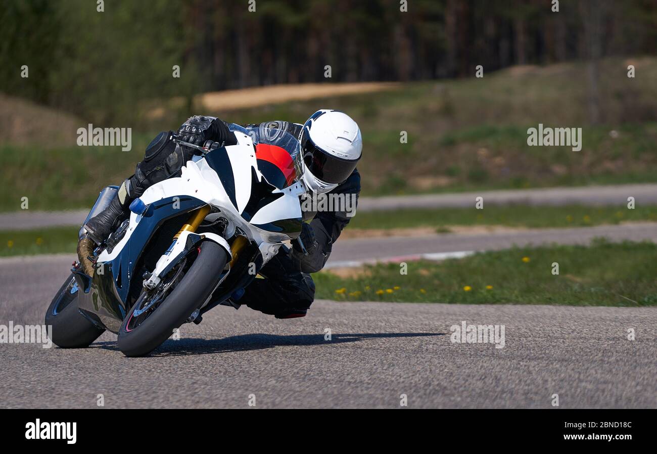 Motorcycle practice leaning into a fast corner on track Stock Photo - Alamy