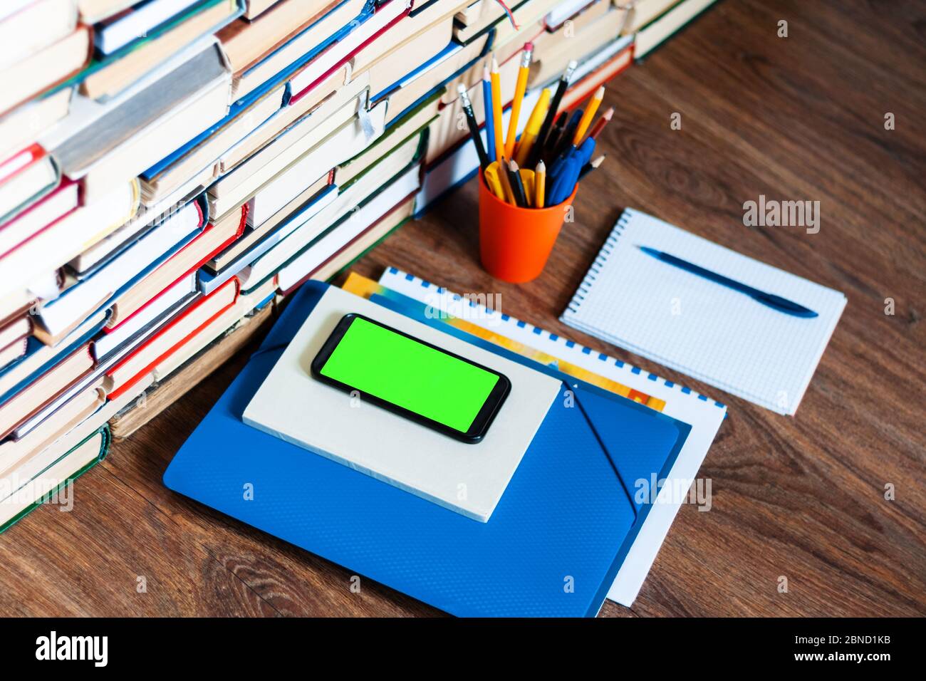 Textbook, notebook, green screen mobile phone smartphone and stack of ...