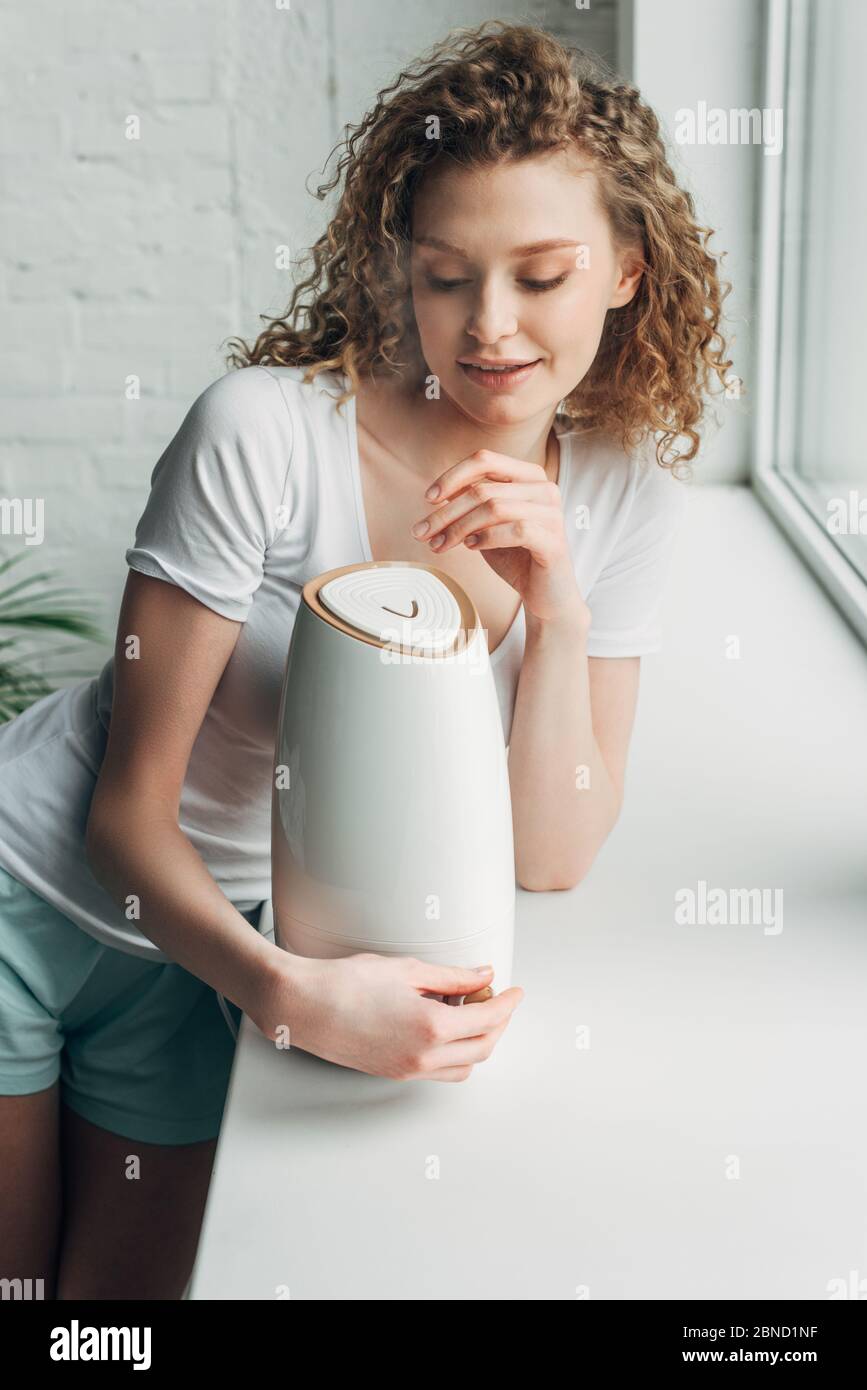 beautiful happy girl with air humidifier on windowsill Stock Photo - Alamy