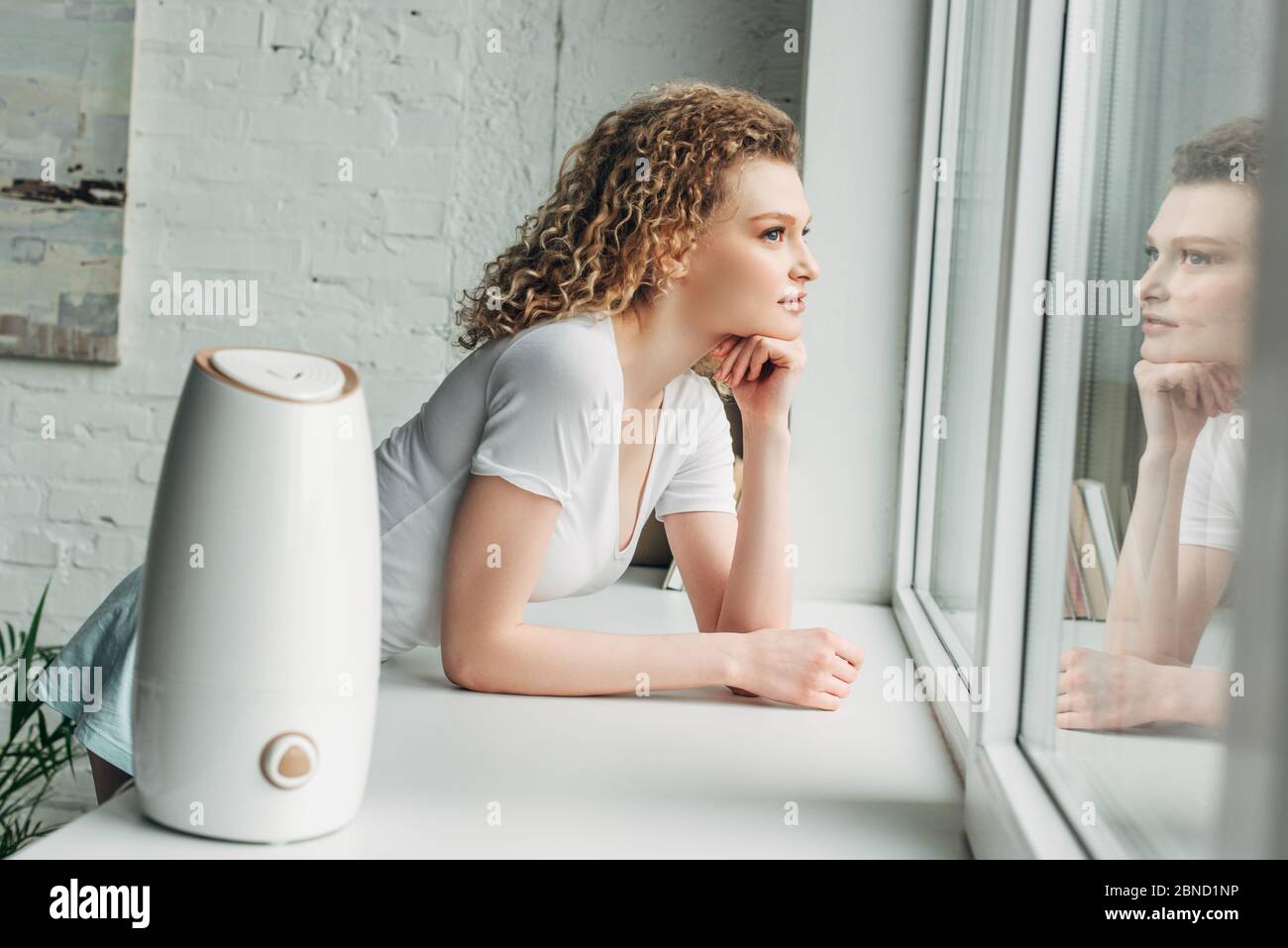 beautiful girl with ultrasonic air purifier on windowsill Stock Photo ...