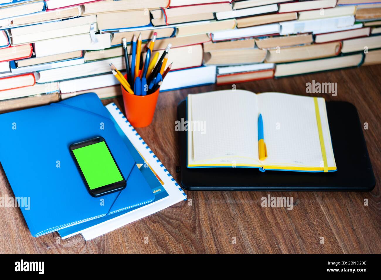 Textbook, notebook, green screen mobile phone smartphone and stack of ...