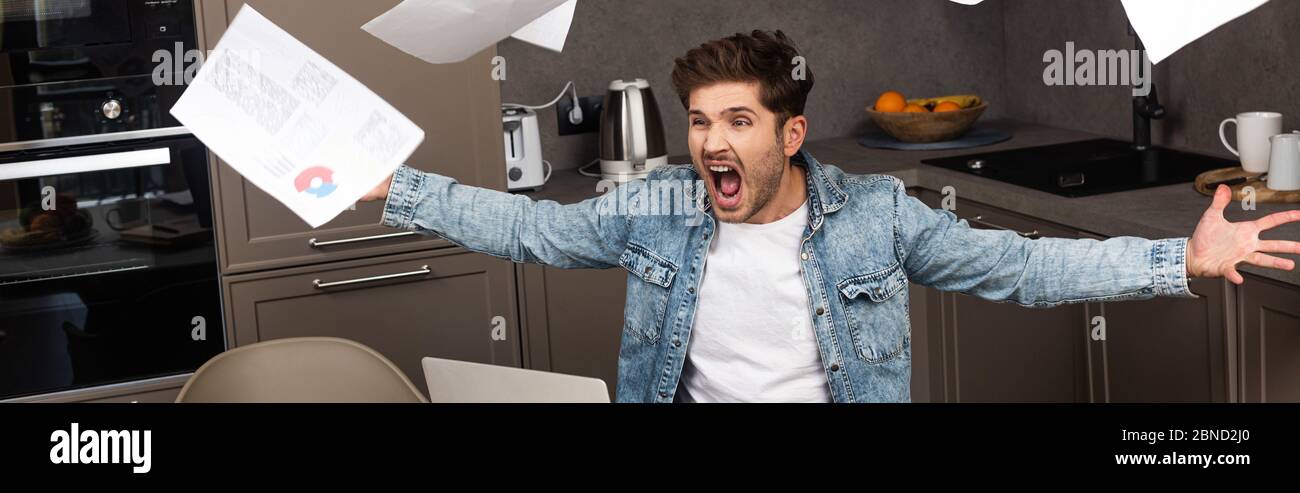 Panoramic crop of teleworker screaming while throwing documents in ...