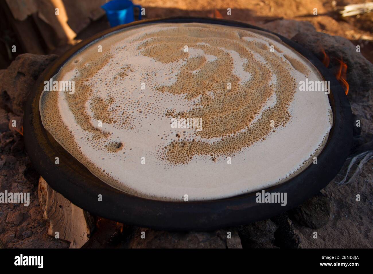 Cooking Injera bread, made with batter from fermented cereals. Jimba ...