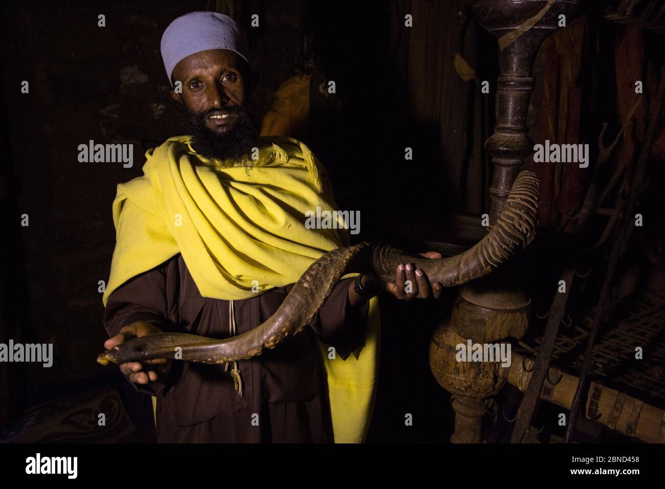Coptic monk of Tana Qirqos Monastery, showing items in the museum. Lake ...