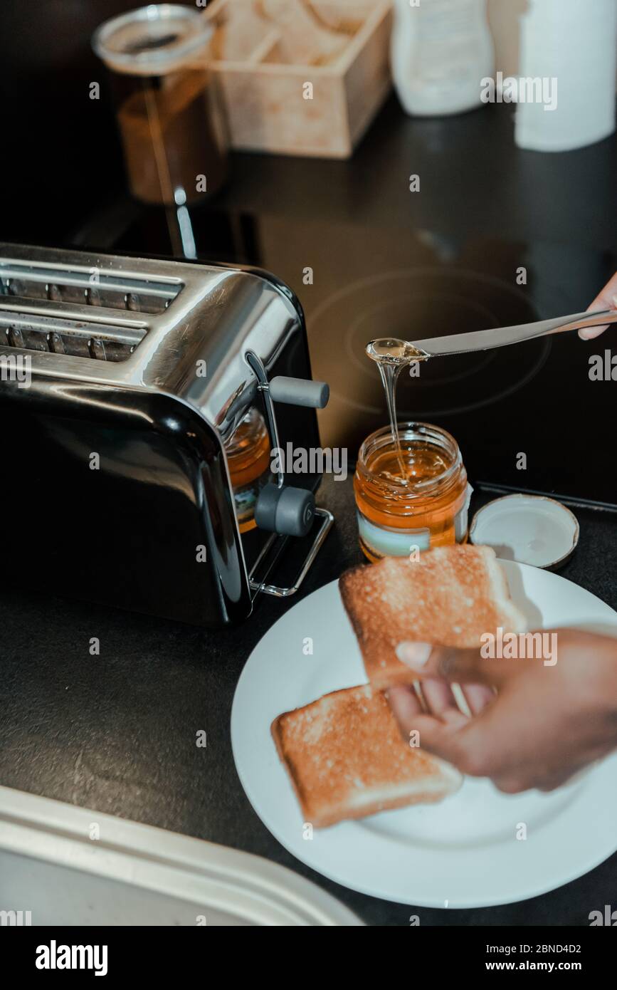 Cropped view of african american woman preparing toast with honey near ...