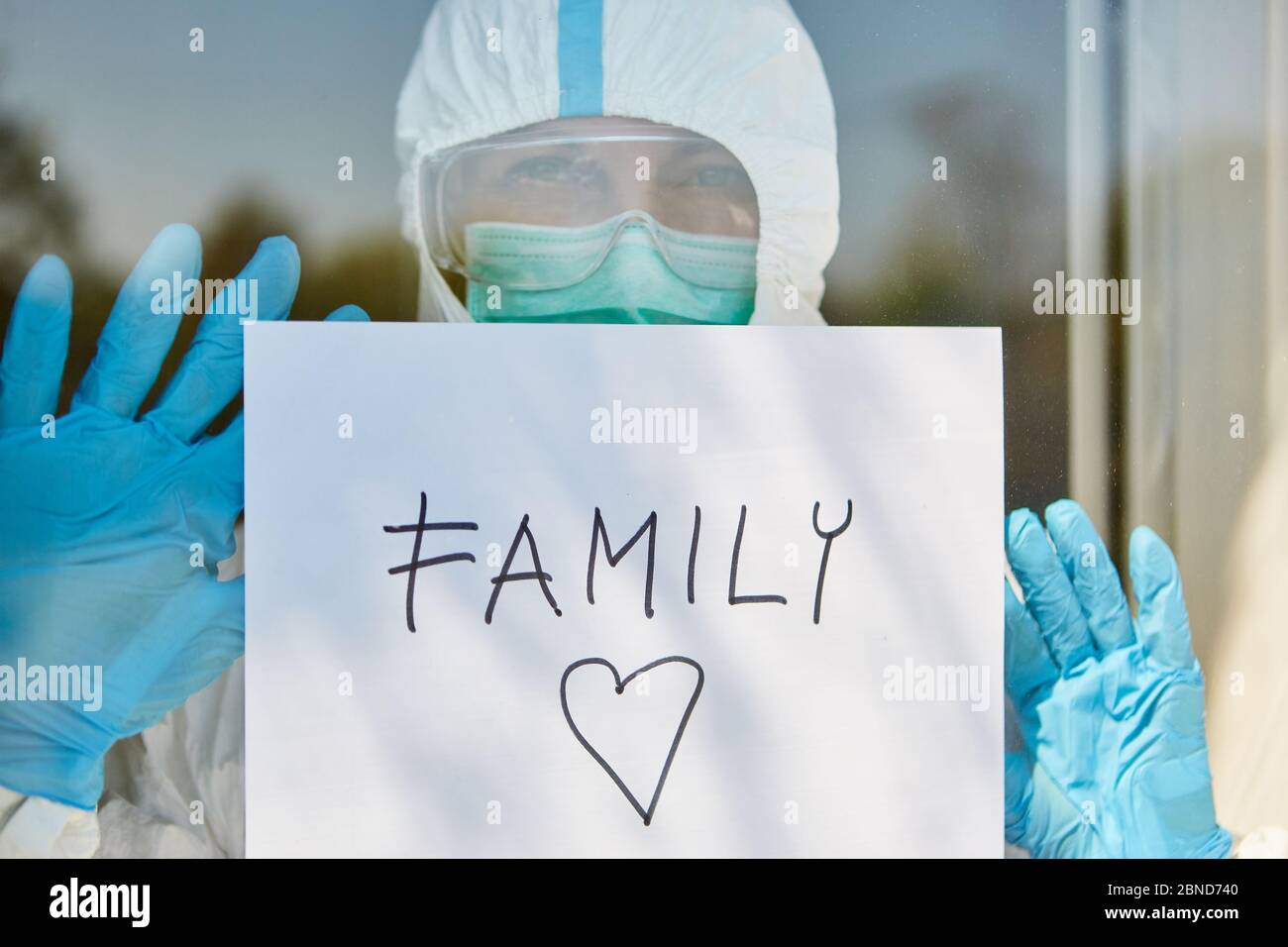 Sign with Family lettering on front door with person in protective ...