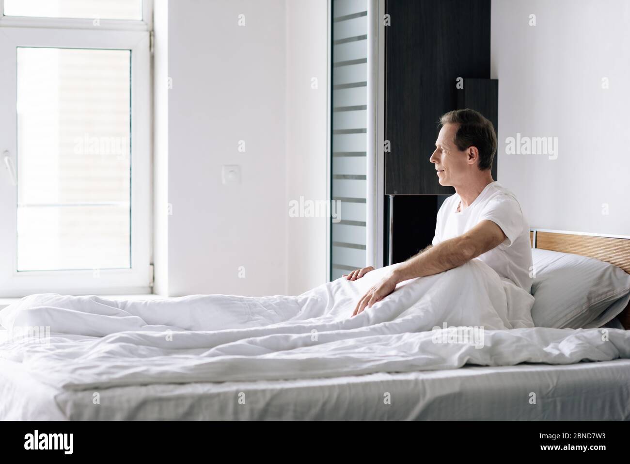 side view of man looking at window in bedroom Stock Photo - Alamy