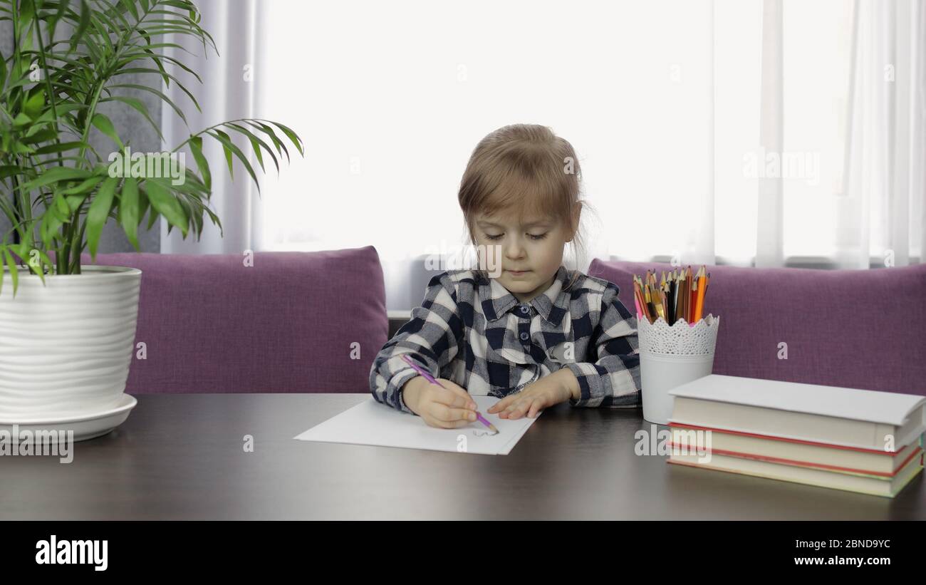 Cute small kid girl artist playing studying alone drawing picture with ...