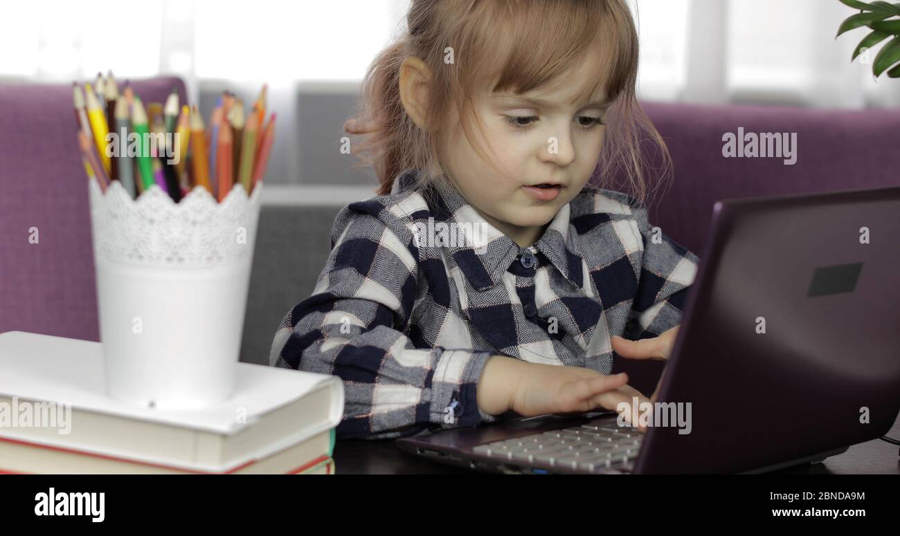 Pretty preschool girl distance online learning at home. Focused cute ...