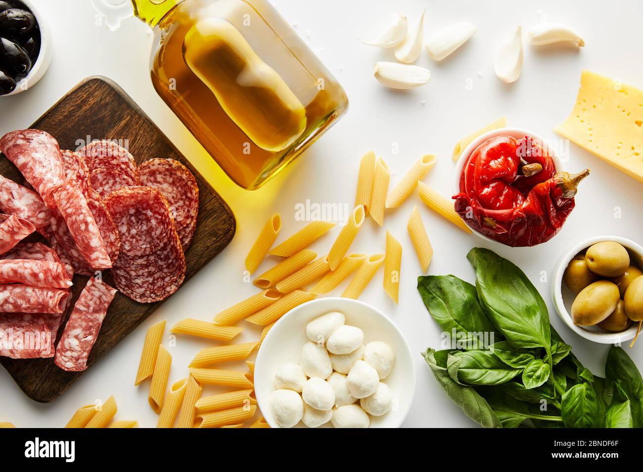 Top view of pasta, bottle of olive oil, meat platter and ingredients on ...