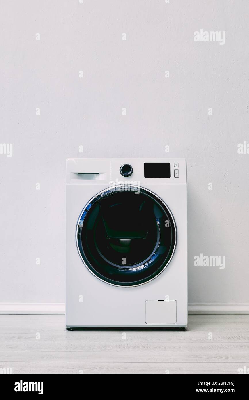 washing machine near white wall in bathroom Stock Photo - Alamy