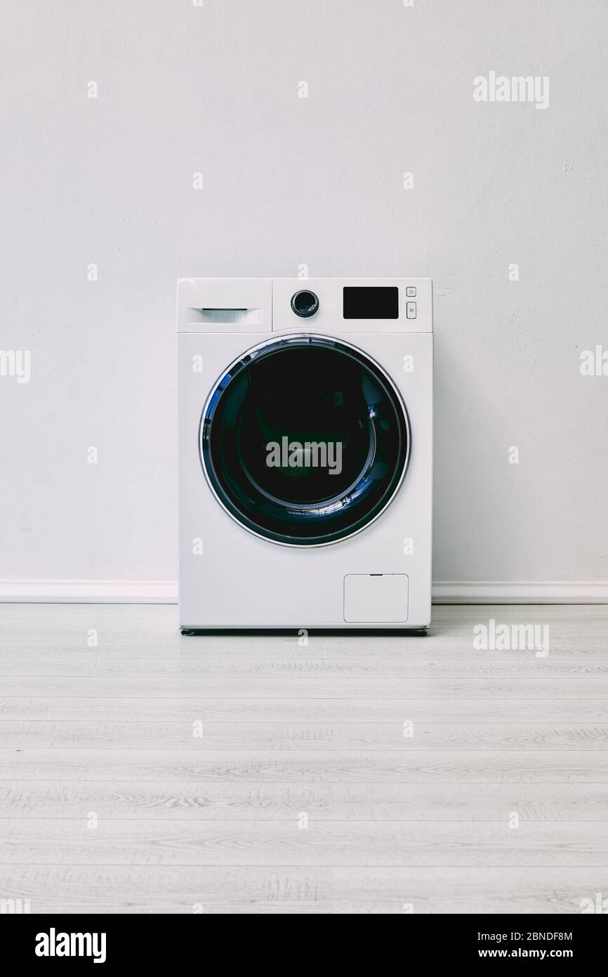 modern washing machine on floor near white wall in bathroom Stock Photo ...