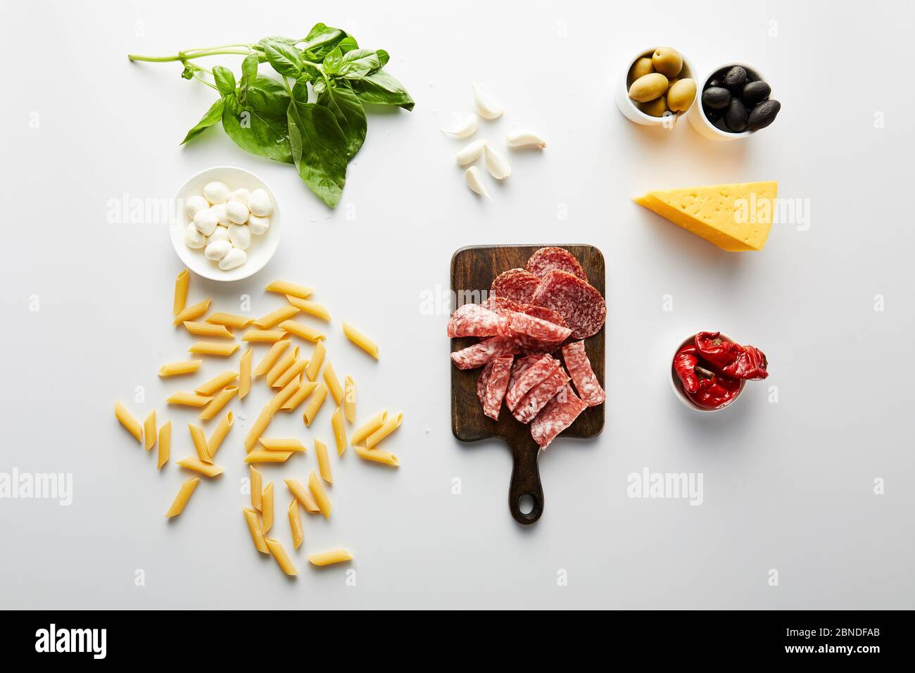 Top view of pasta, meat platter, cheese and ingredients on white Stock ...