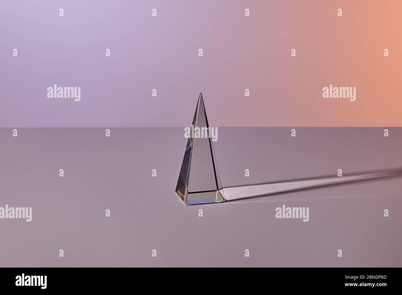 crystal transparent pyramid with light reflection on grey background ...