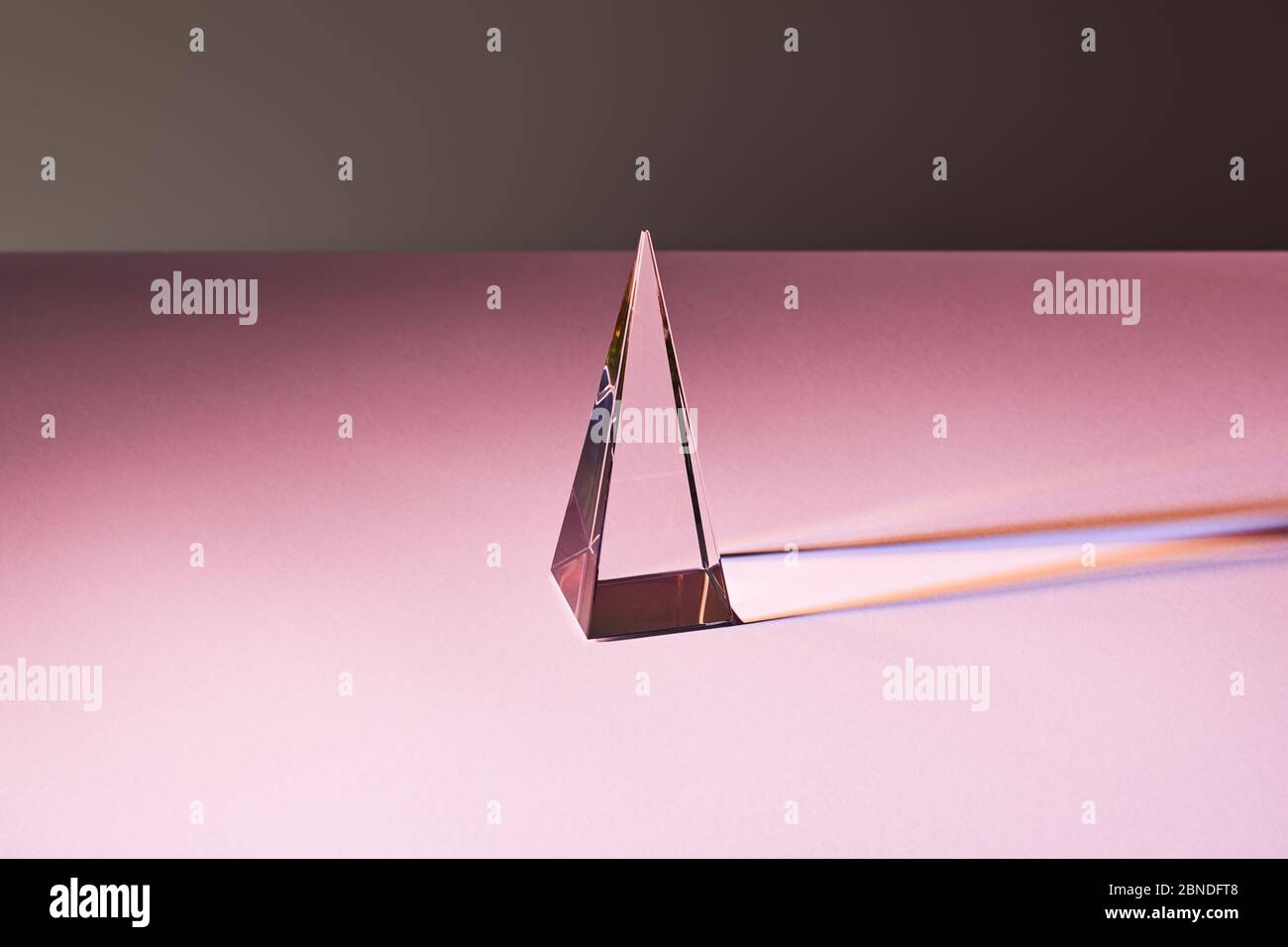 crystal transparent pyramid with light reflection on pink surface Stock ...