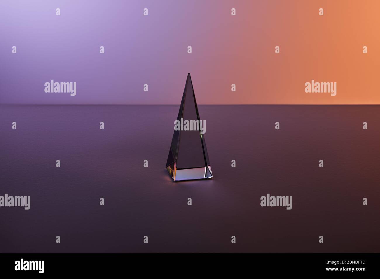 crystal transparent pyramid with light reflection on dark purple ...