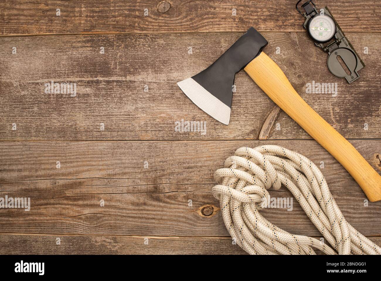 top view of axe, hiking rope and compass on wooden surface Stock Photo ...